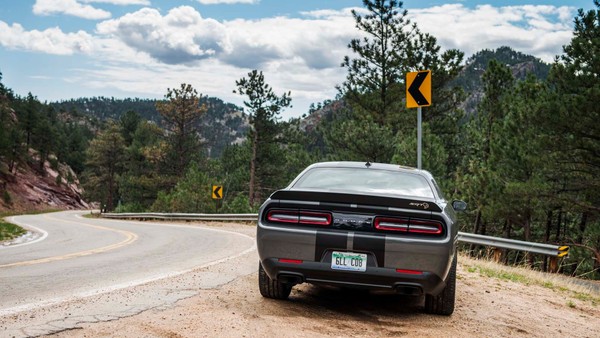 Dodge Challenger Hellcat and Ford F-150 Raptor race around, over a mountain